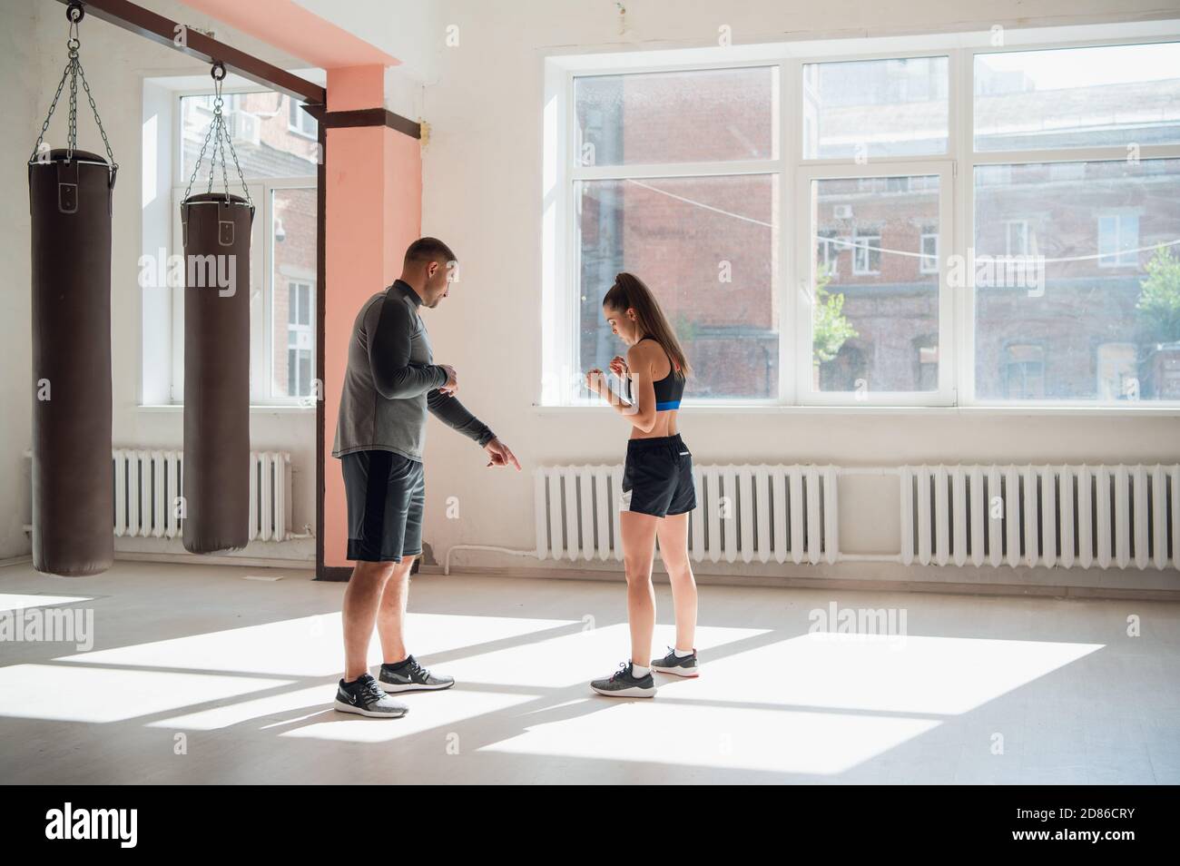 A young attractive boxing coach prepares a pretty girl for competition ...