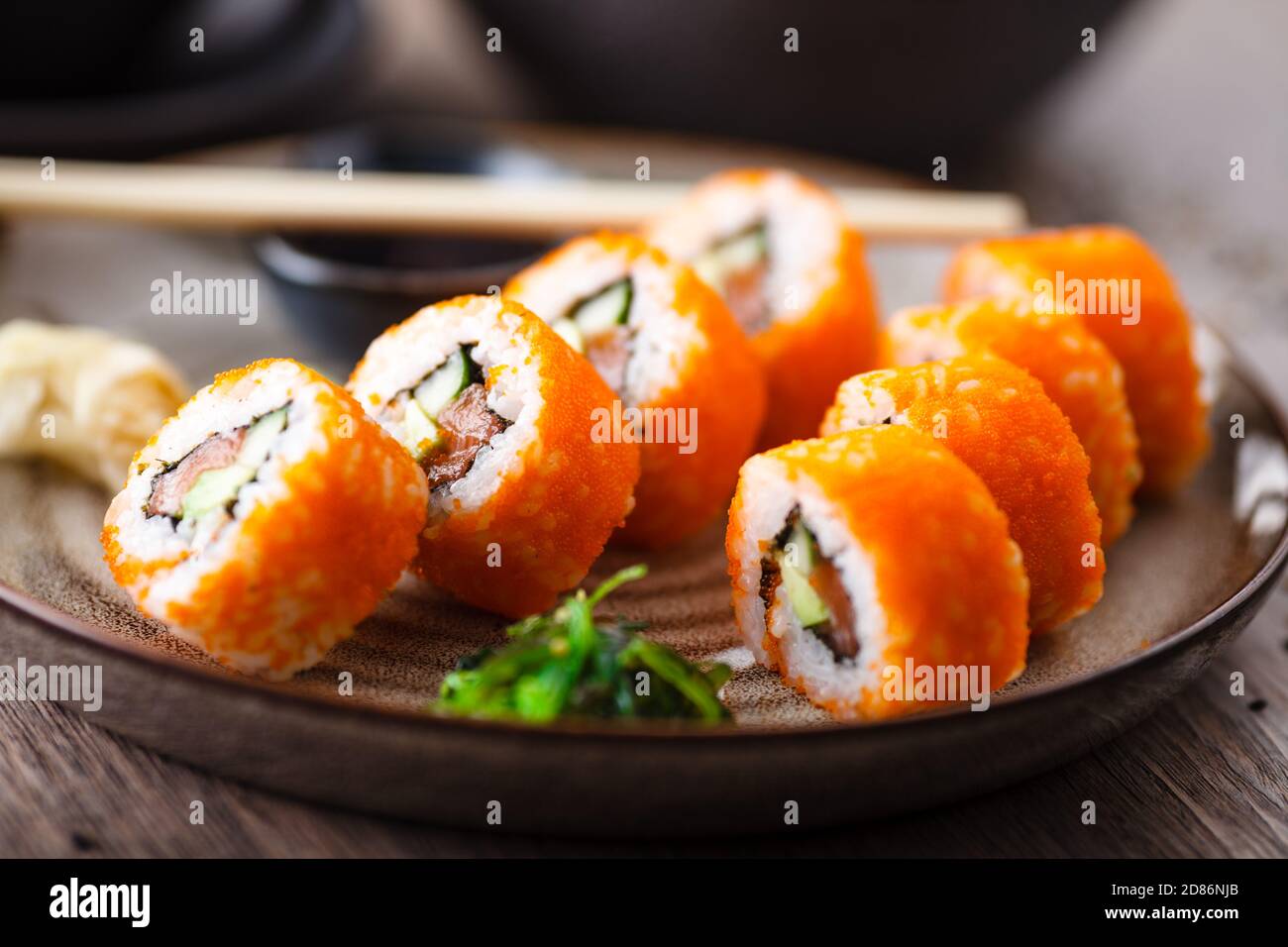 Sushi maki rolls with salmon, avocado, cucumber, flying fish roe on a ...