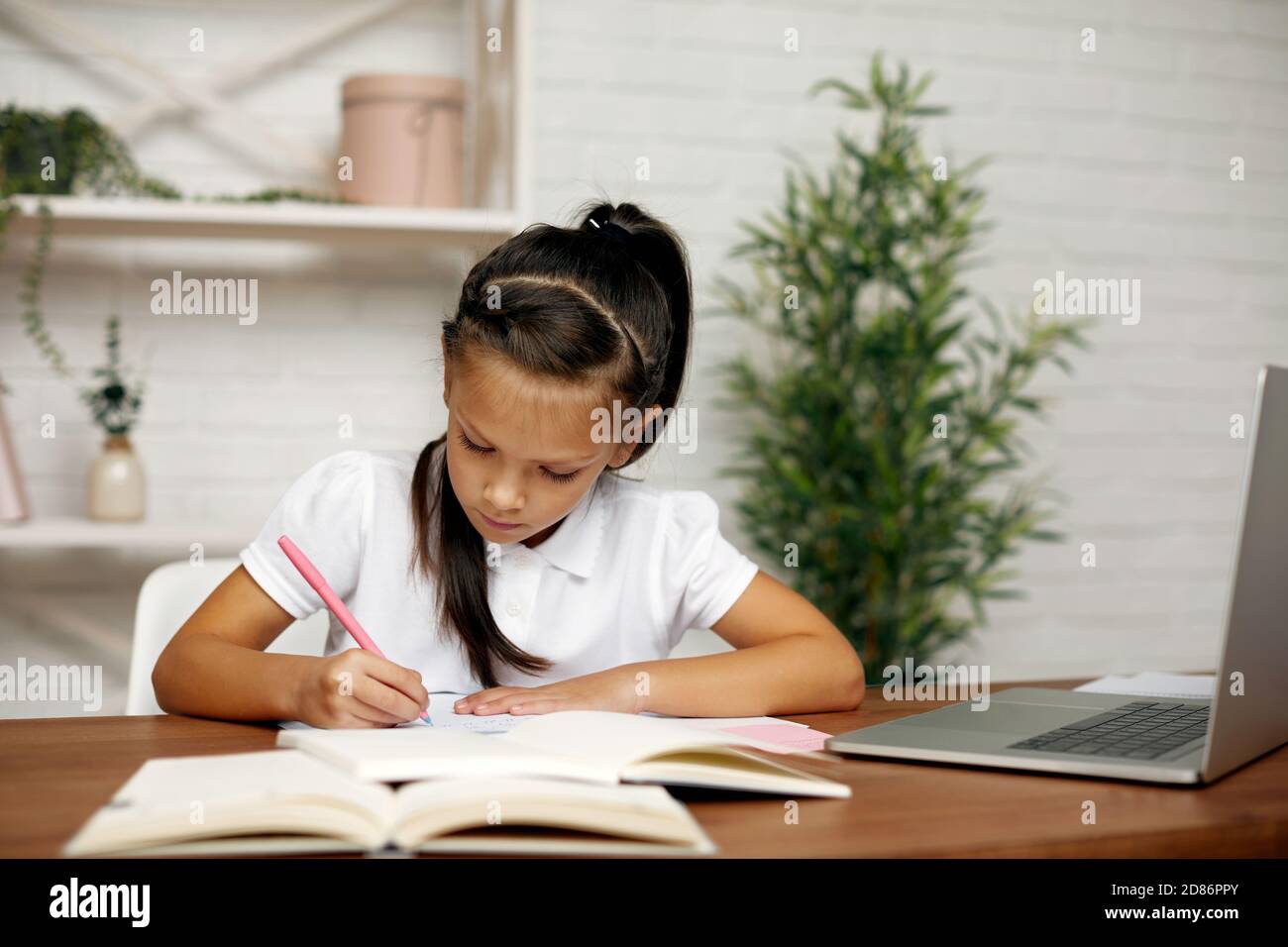 cute little child girl using computer for studying online e-learning ...