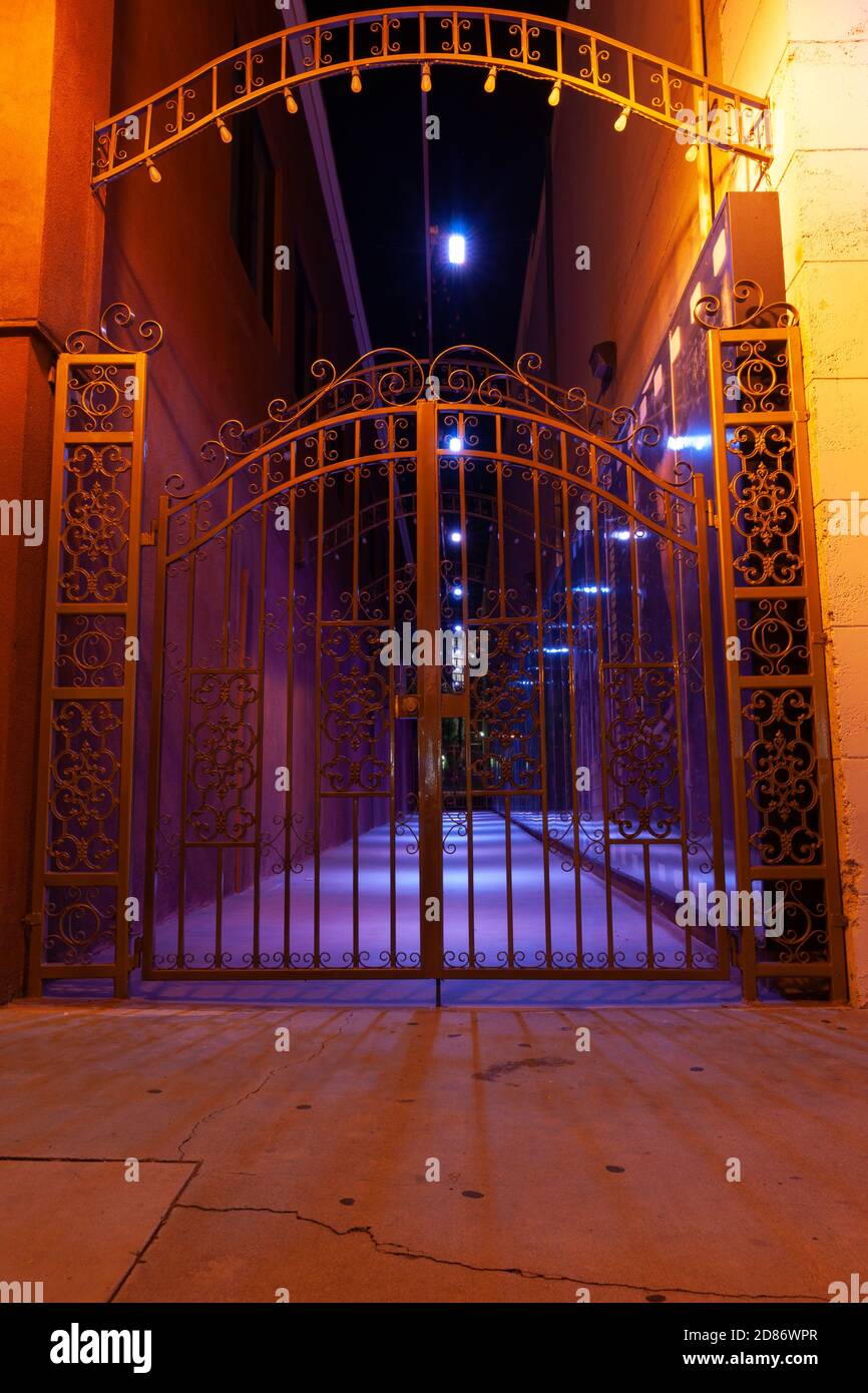 Ornate wrought iron gate under festive night lights at entrance of ...