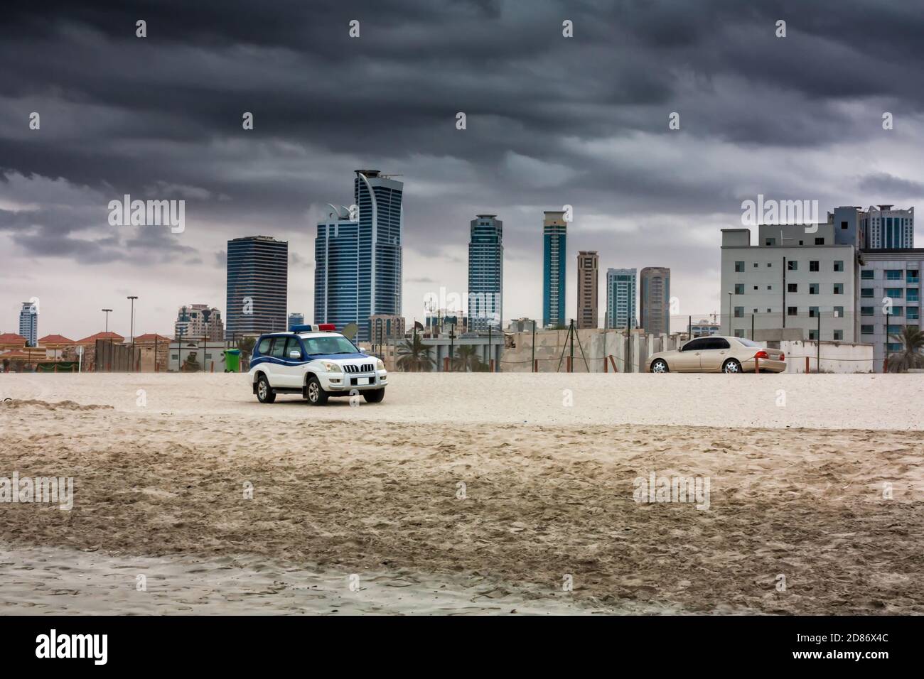 Police off-road car and city sedan on a sandy beach in the background ...