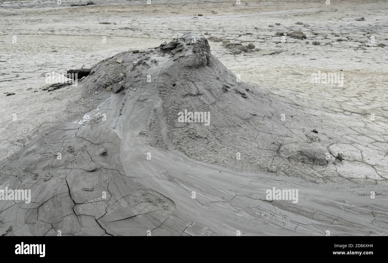 Close up view on crater of mud volcano. Slow flow of underground mud ...