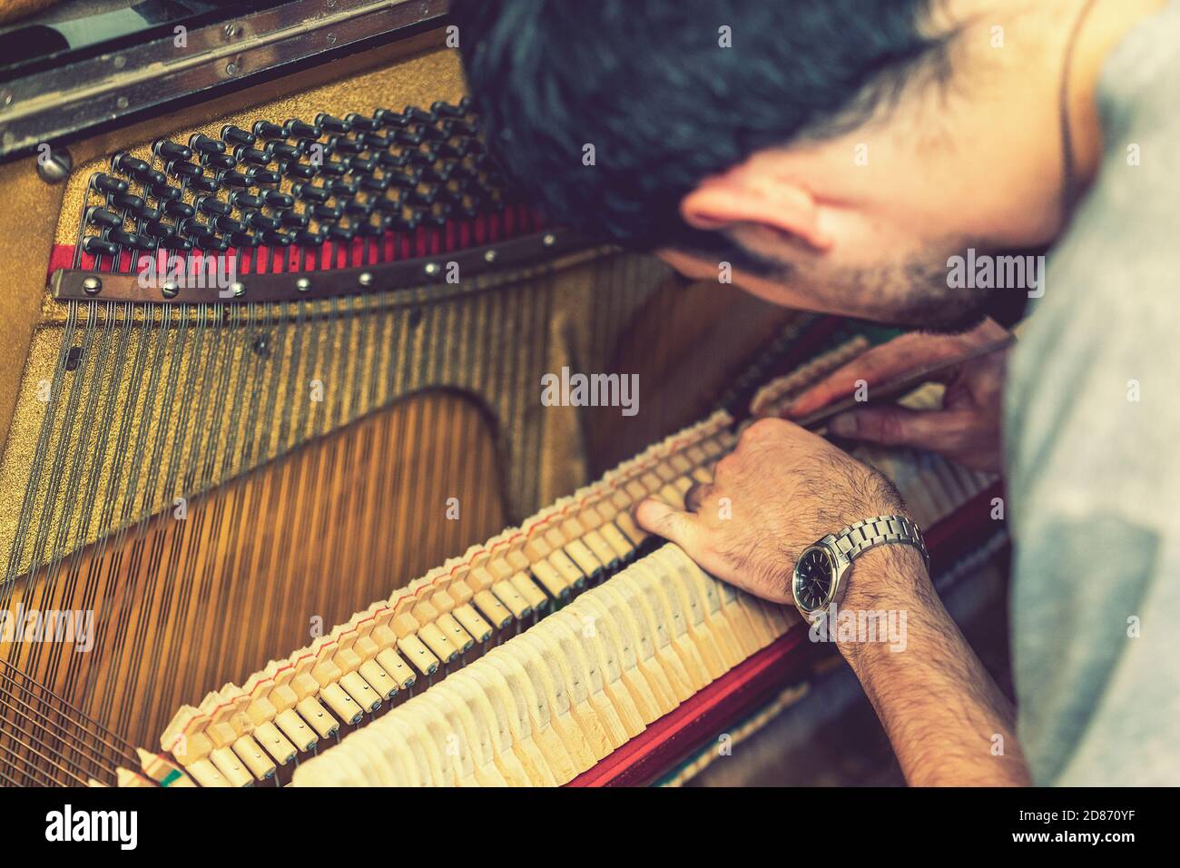 Piano tuning process. closeup of hand and tools of tuner working on ...