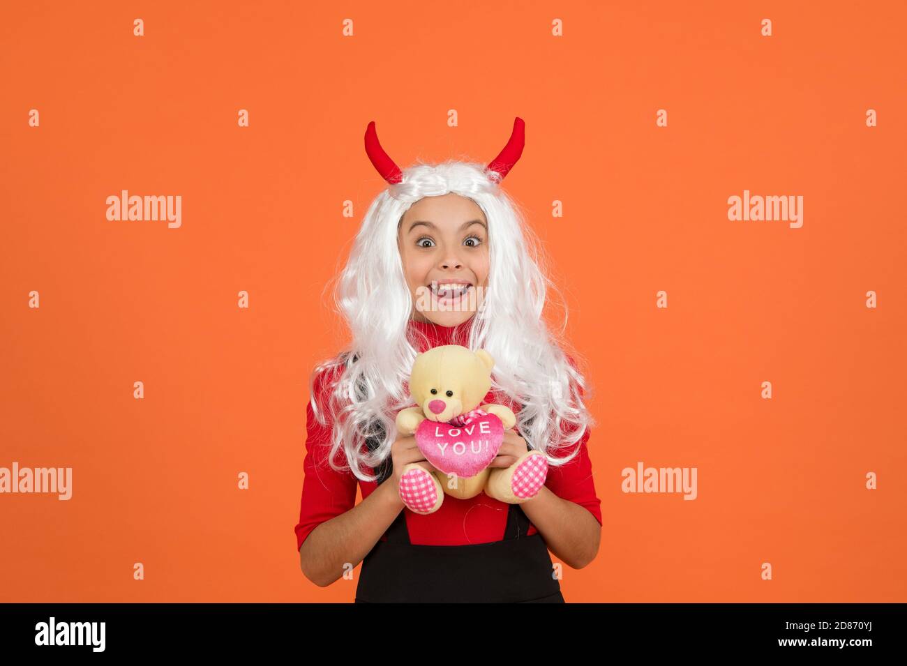 thank you. smiling child in devil horns with teddy bear toy. kid has ...