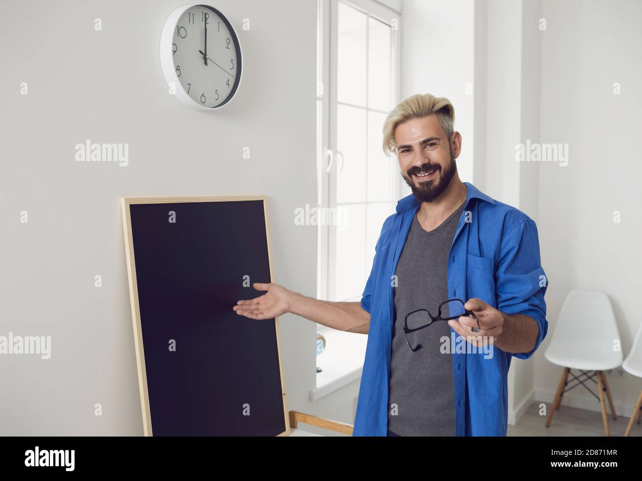 Smiling male worker explaining information from chalkboard Stock Photo ...