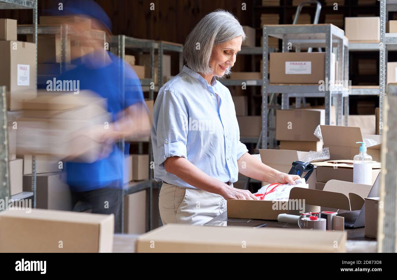 Warehouse workers hurry in blur motion to deliver parcels. Fast ...