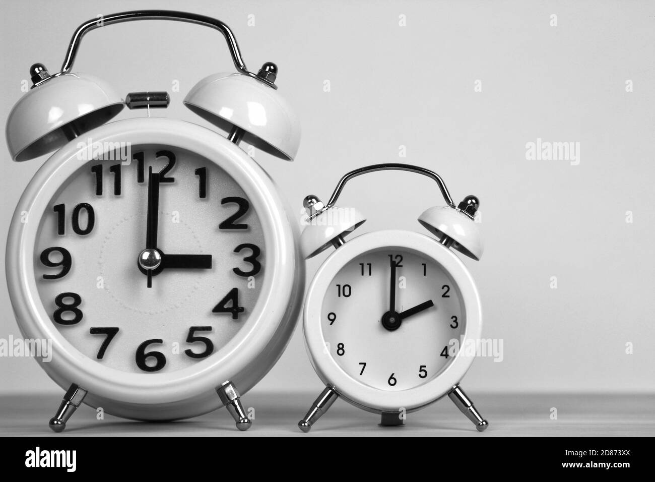 Clocks marking winter time change over white background Stock Photo - Alamy