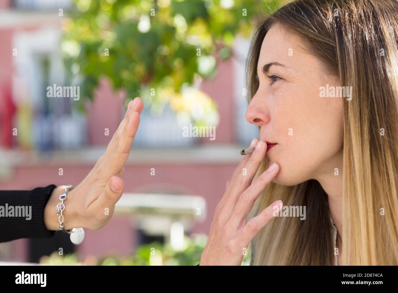 Close up portrait portrait of young caucasian woman smoking while one ...