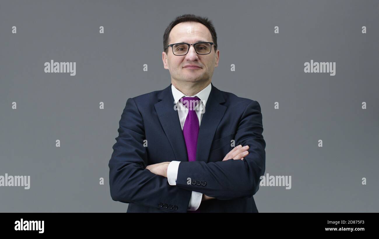 Successful self-confident handsome business owner smiling, folds arms ...