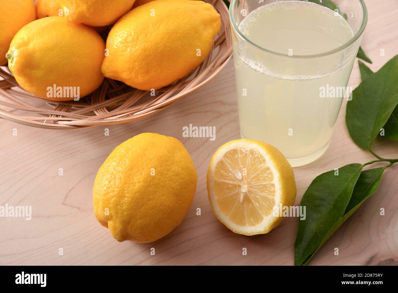 Freshly lemon with water beverage on wooden kitchen bench. Top elevated ...