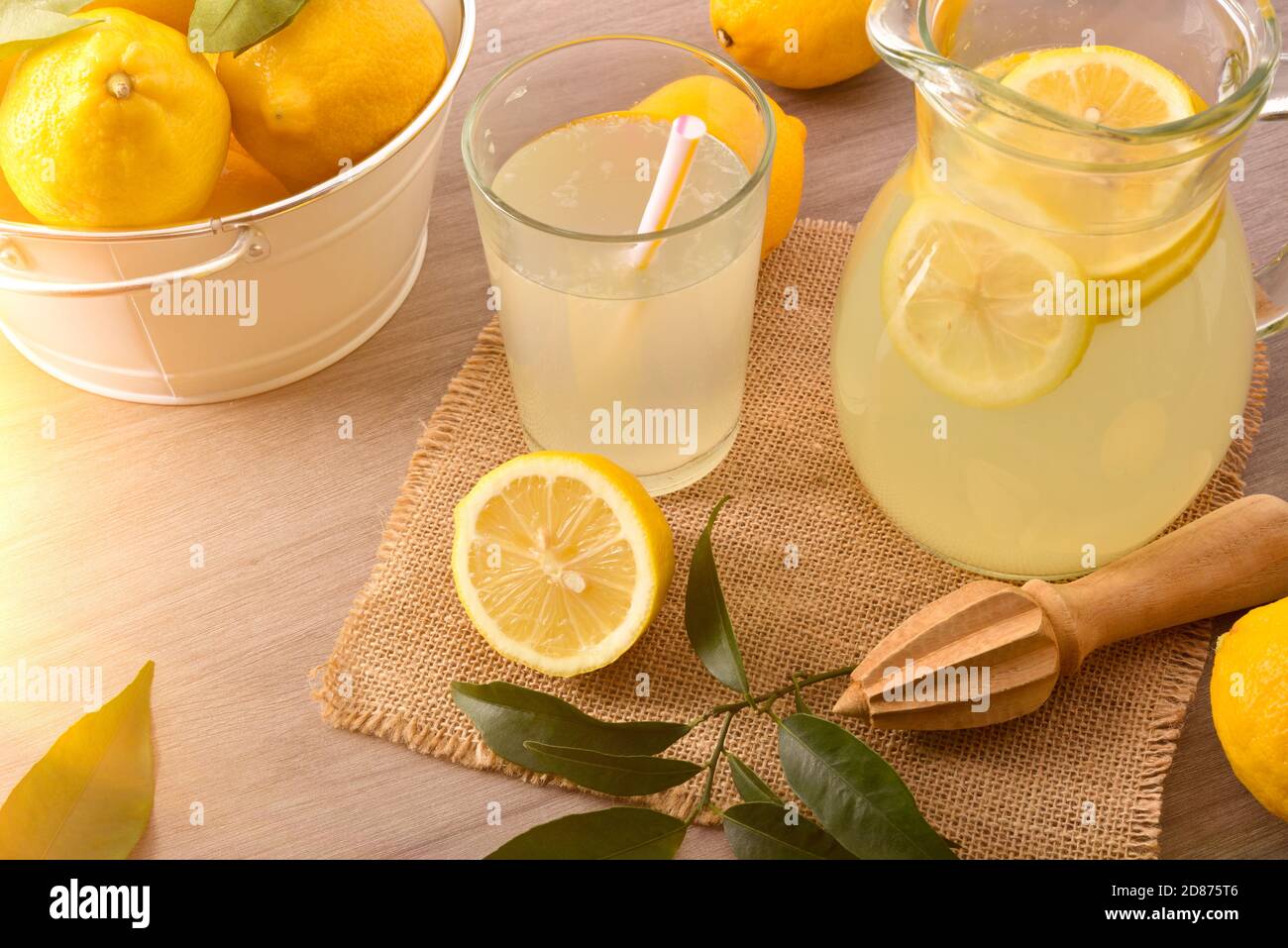 Homemade lemonade on kitchen table with basket full of lemons. Top ...