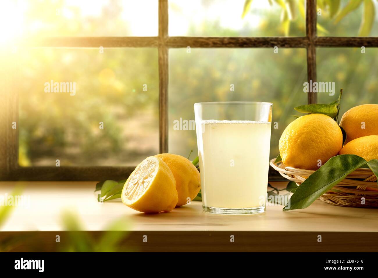 Homemade lemonade on kitchen with basket full of lemons with a window ...