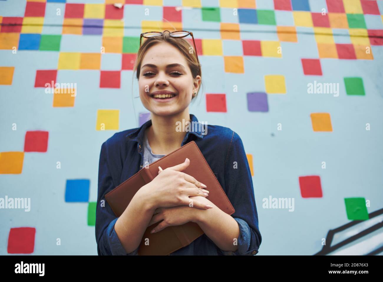 Woman student book in hand emotions model and multi-colored wall Stock ...