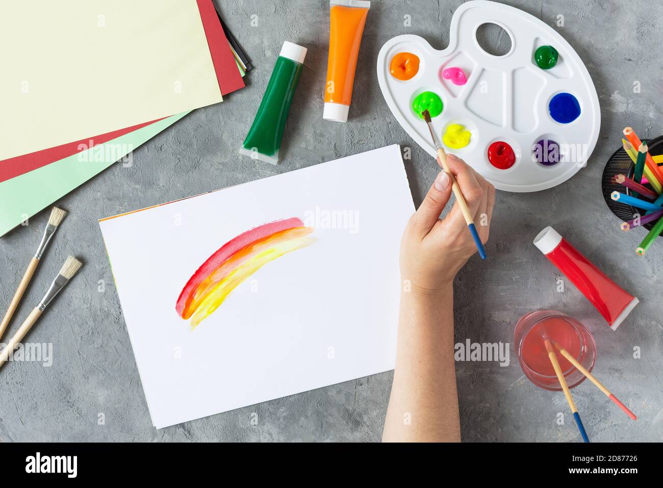 Woman hand painting rainbow in sketchbook with pain brush with art ...