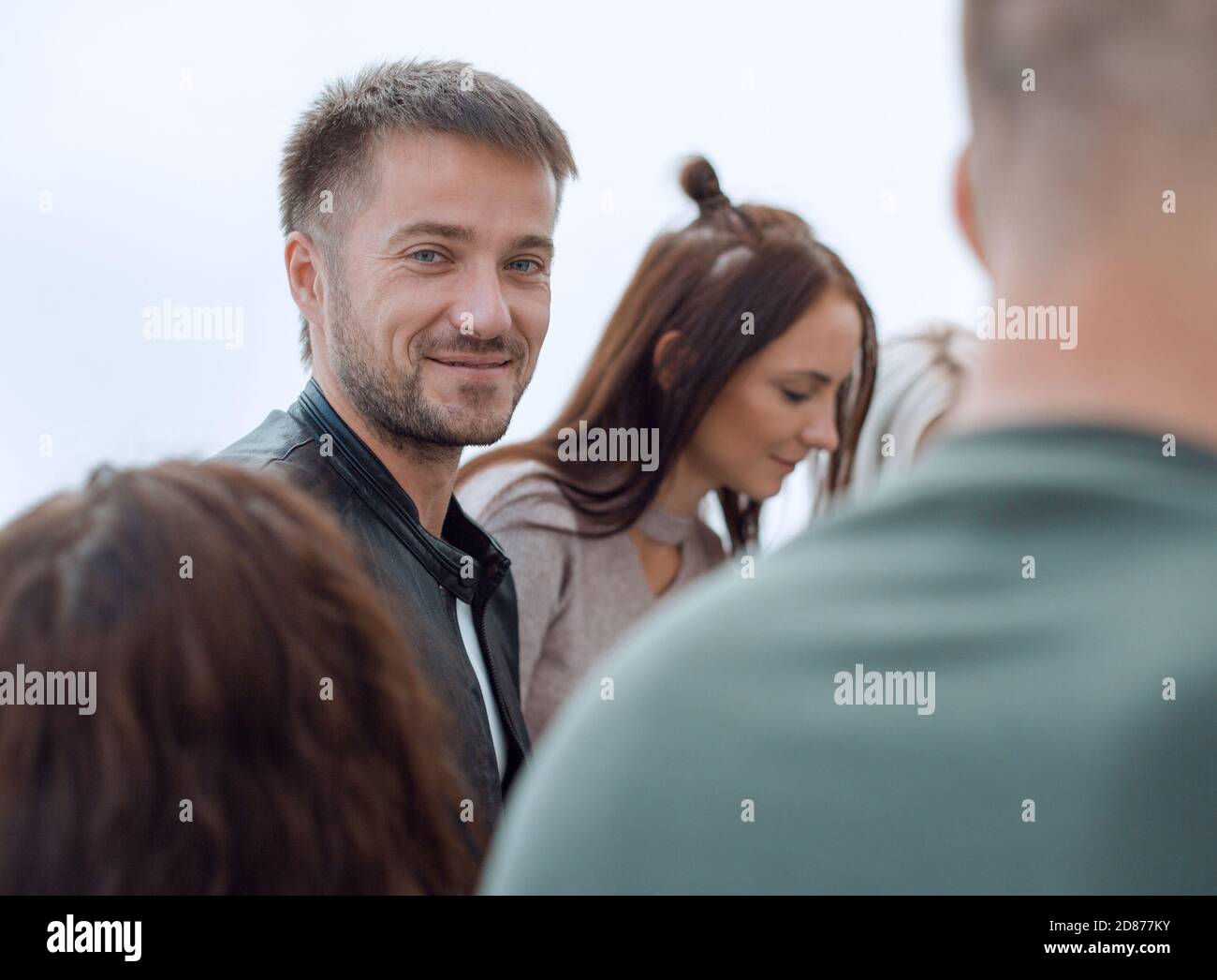 attractive young man sitting in the circle of his friends Stock Photo ...