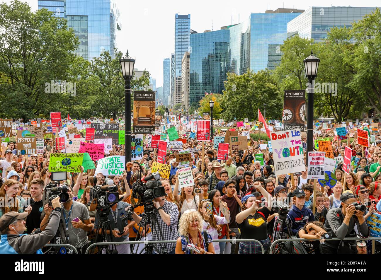 Protesters gather at the Queen's Park while holding placards expressing ...