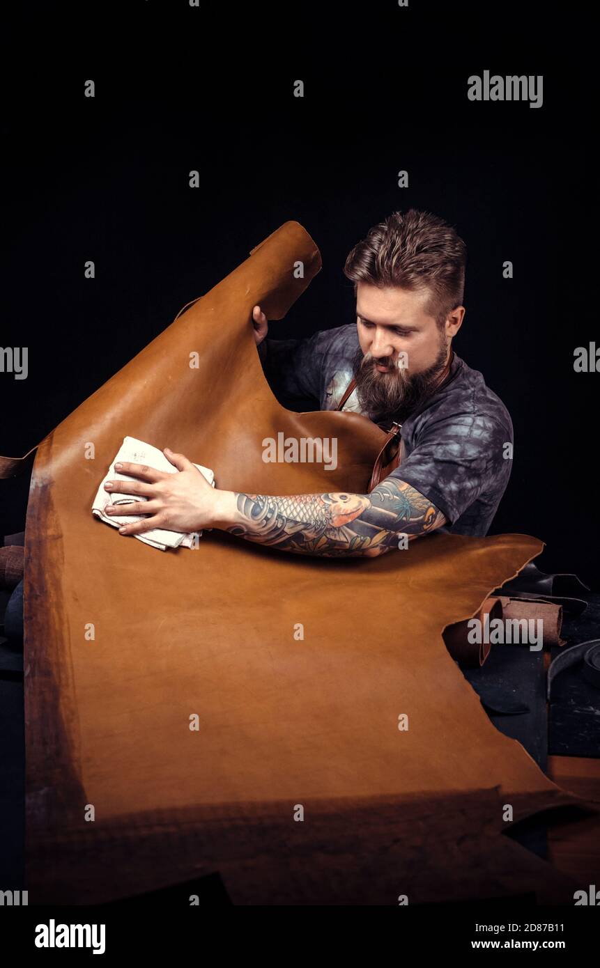 Leather Artist working on a new leather product in leather studio Stock ...