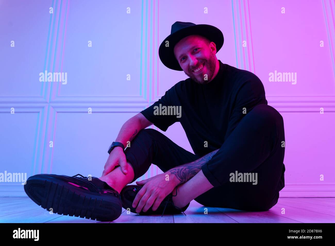 Fashionable guy. Studio shot in dark studio with neon light. Portrait ...