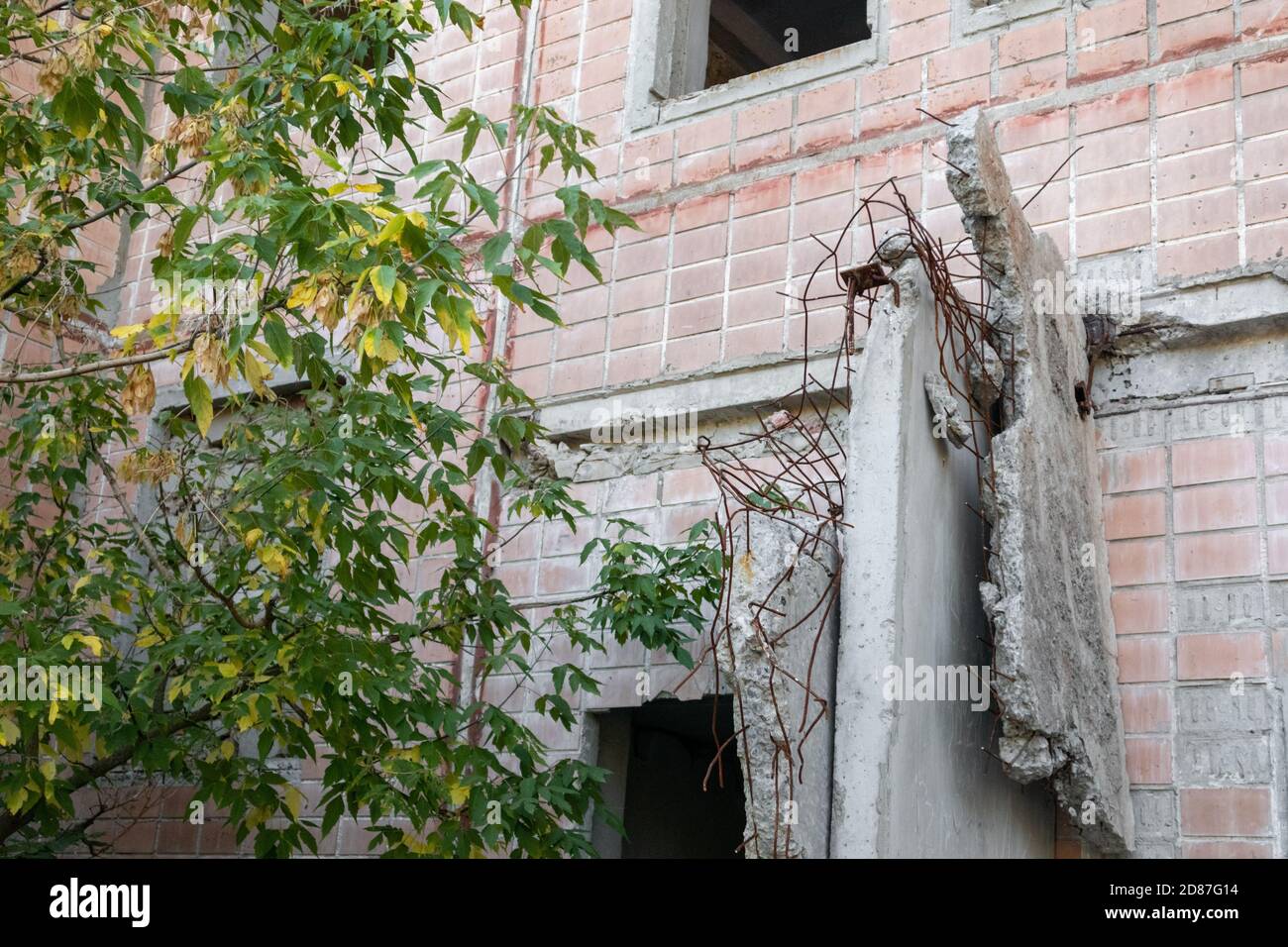 Crashed entrance to abandoned soviet building with red tiled facade and ...