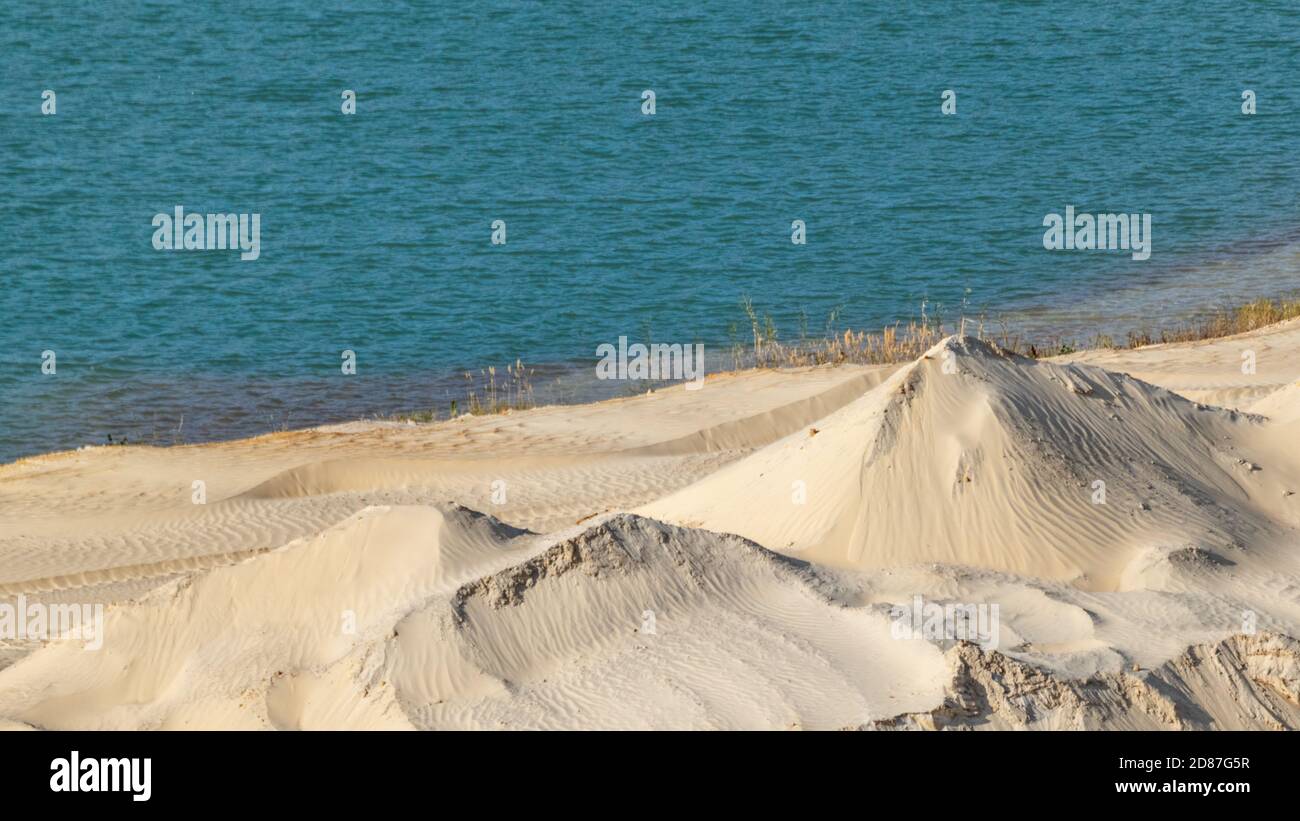 Yellow sand dunes and blue water natural desert terrain. Rippled ...