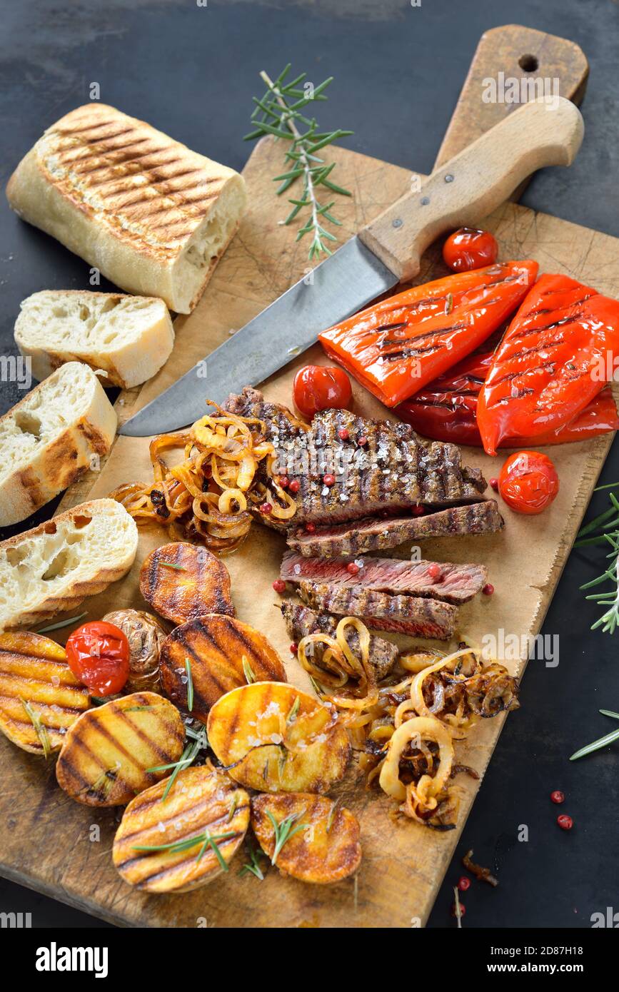 Grilled beef steak with mixed vegetables and crusty Italian bread Stock ...