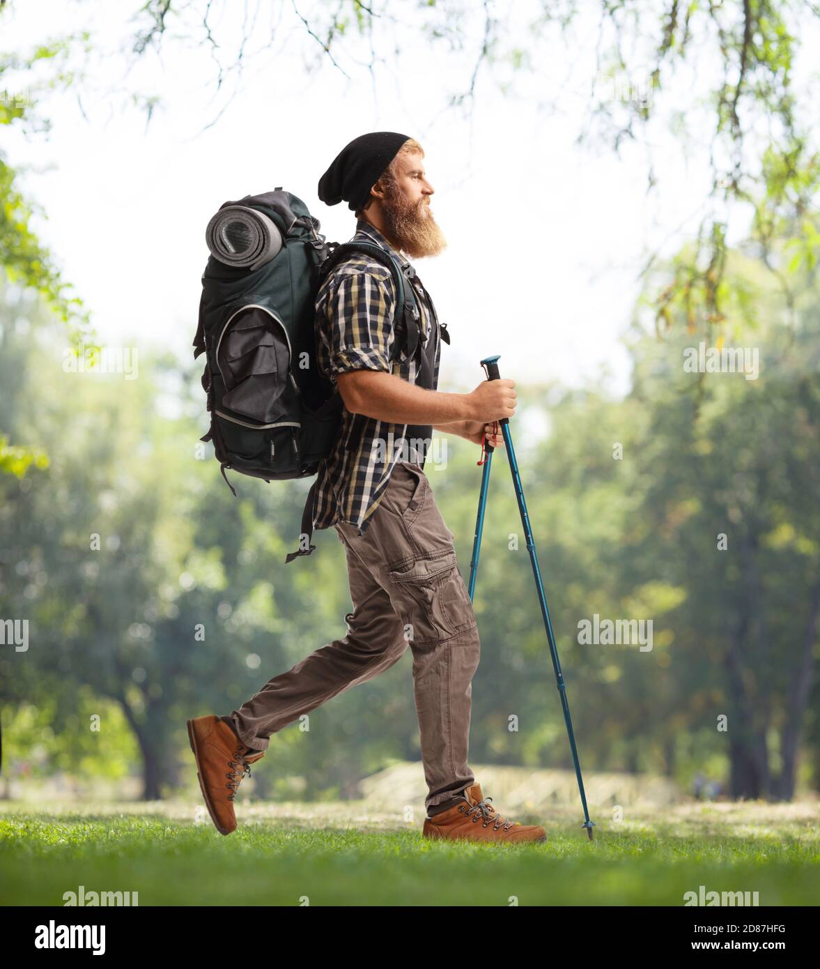 Full length profile shot of a young bearded hiker with a backpack and ...