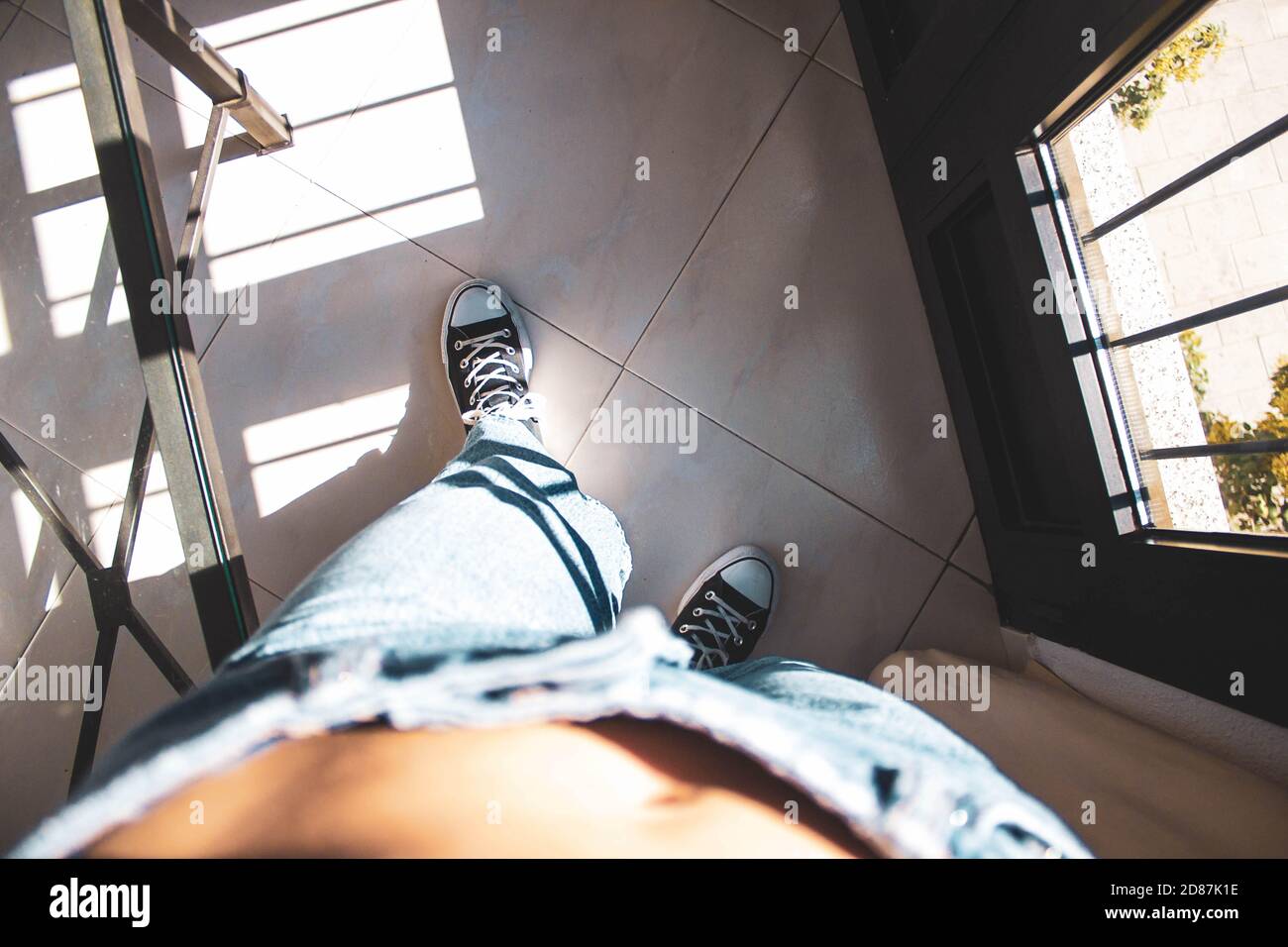 legs of woman in jeans next to the window with lights and shadows Stock ...