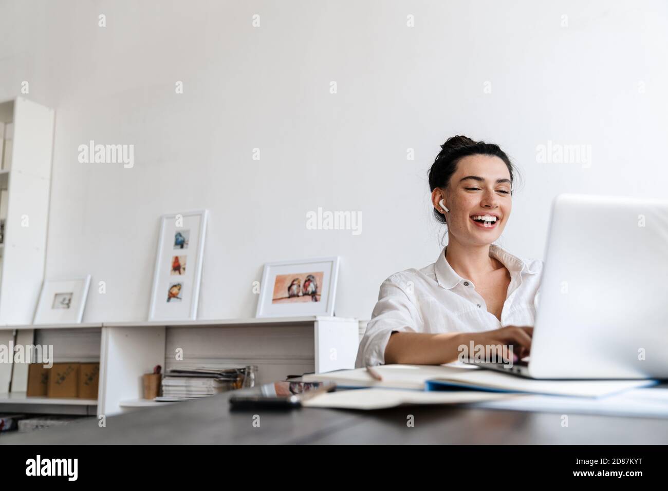 Happy young woman on a video call through laptop computer while sitting ...