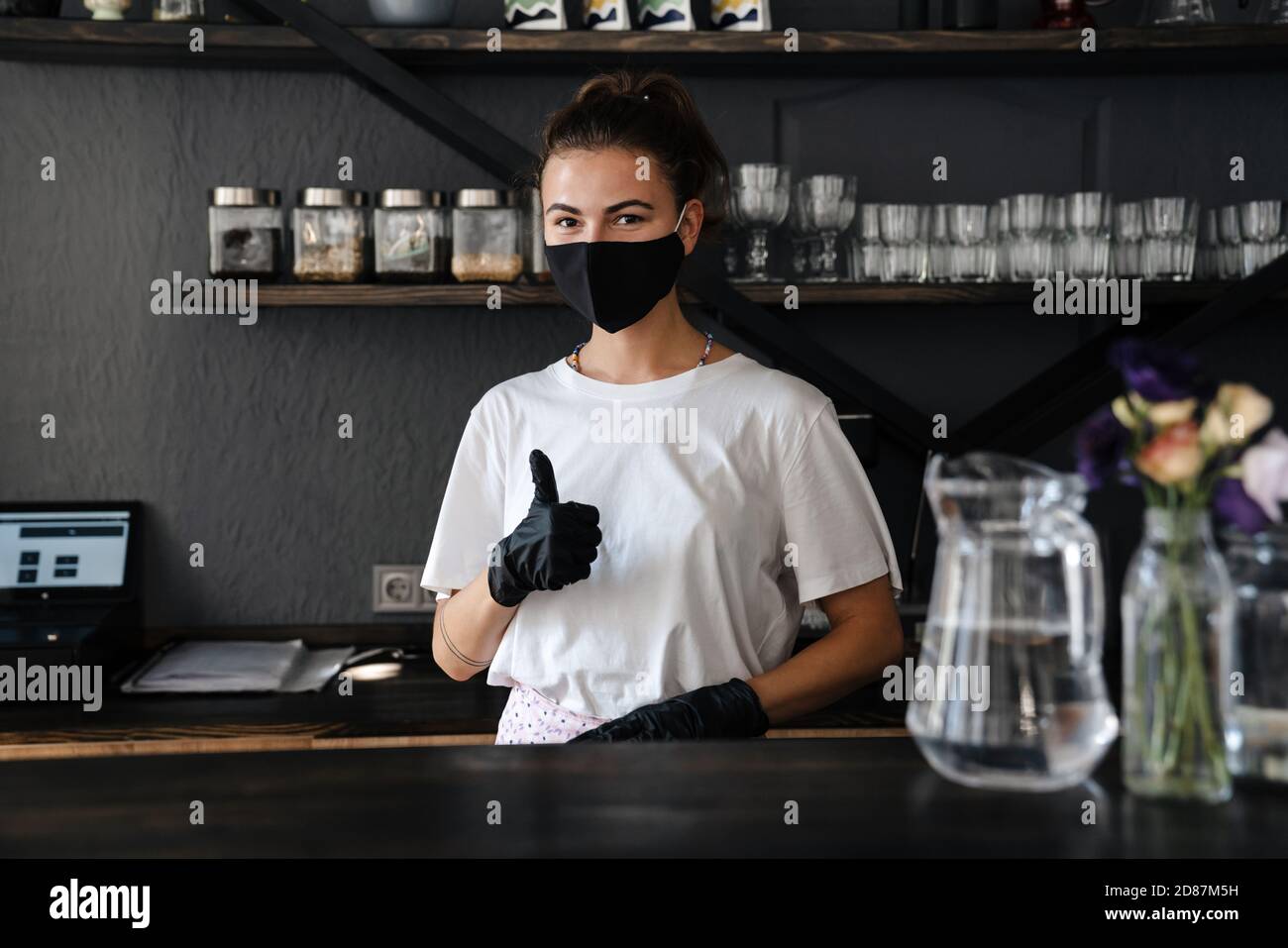 Business owner and barista wearing face mask and smiling after ...