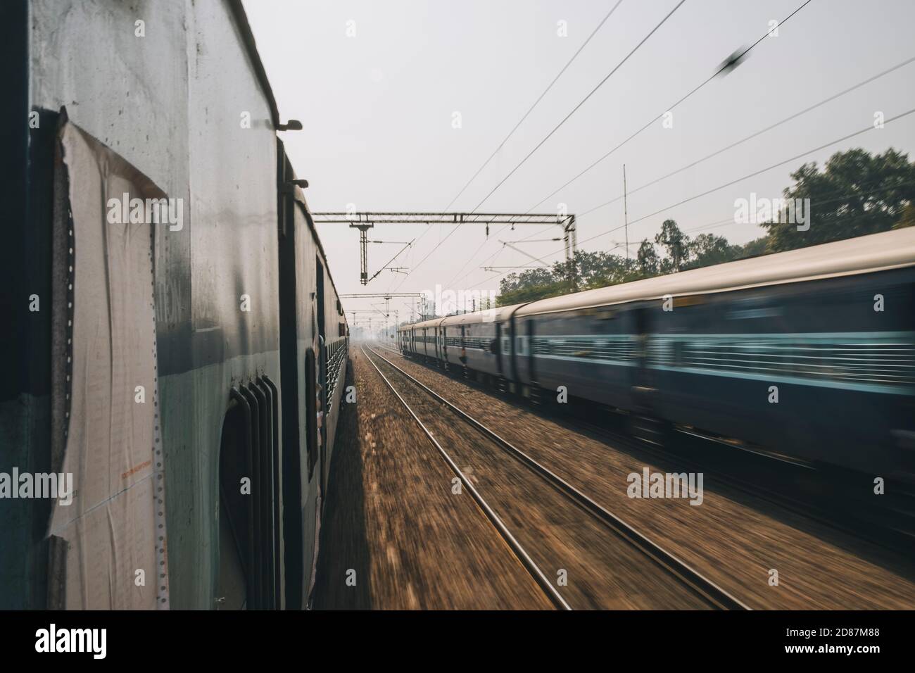 Ordinary express train on a trip from New Delhi to Agra just passing by ...