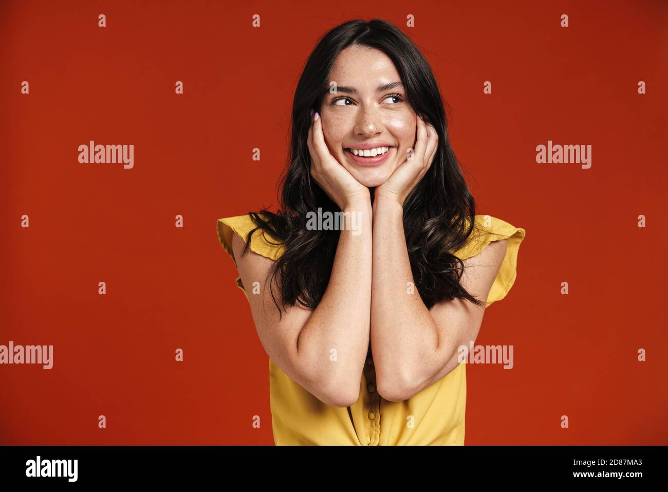 Image of young cheerful woman smiling and grabbing her face isolated ...