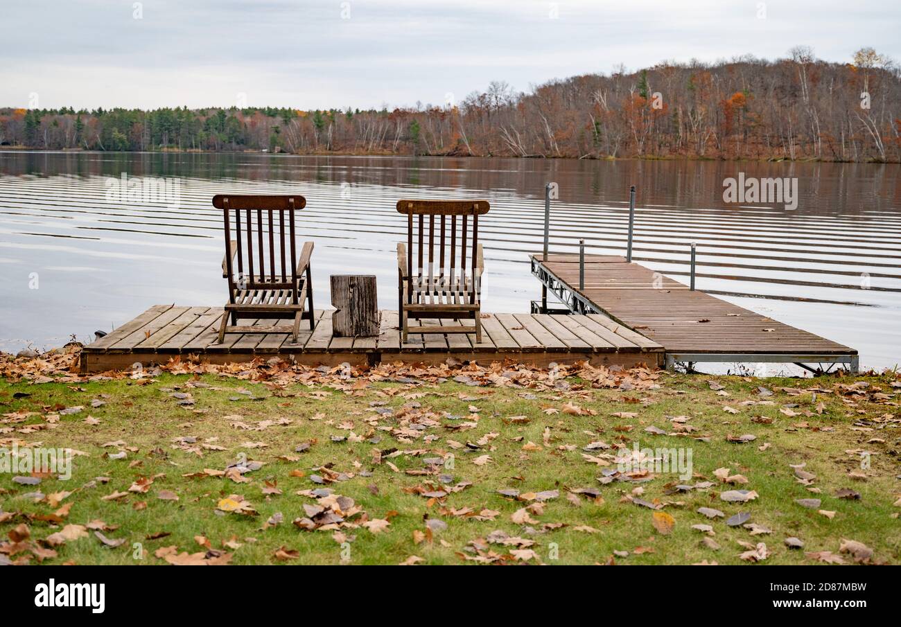 Seating for two on lake in the fall Stock Photo - Alamy
