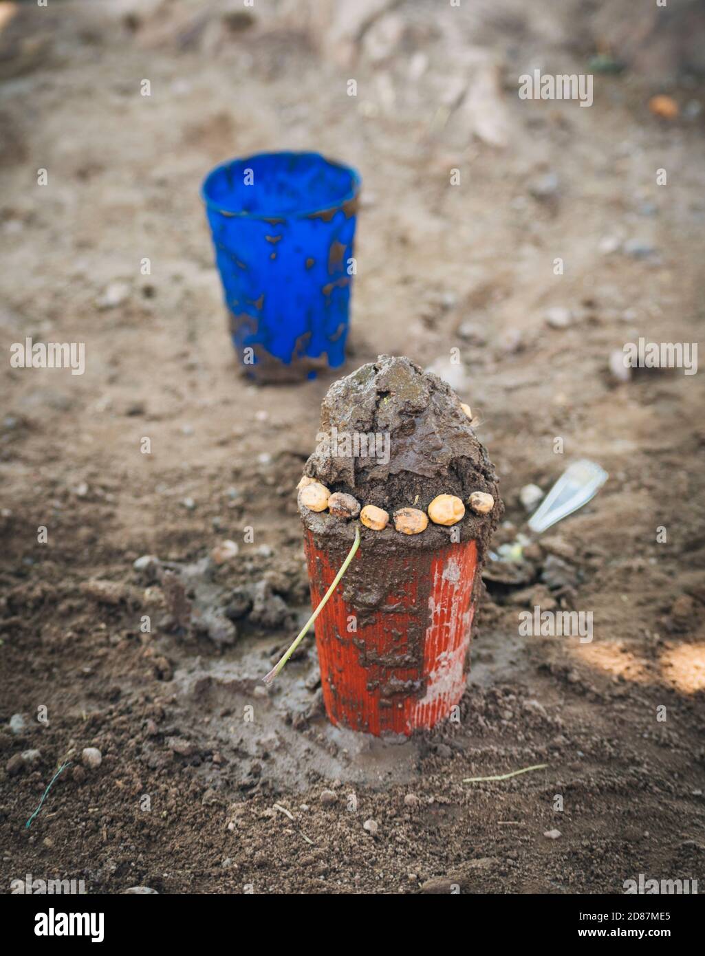 plastic cup filled with mud by girls playing Stock Photo - Alamy