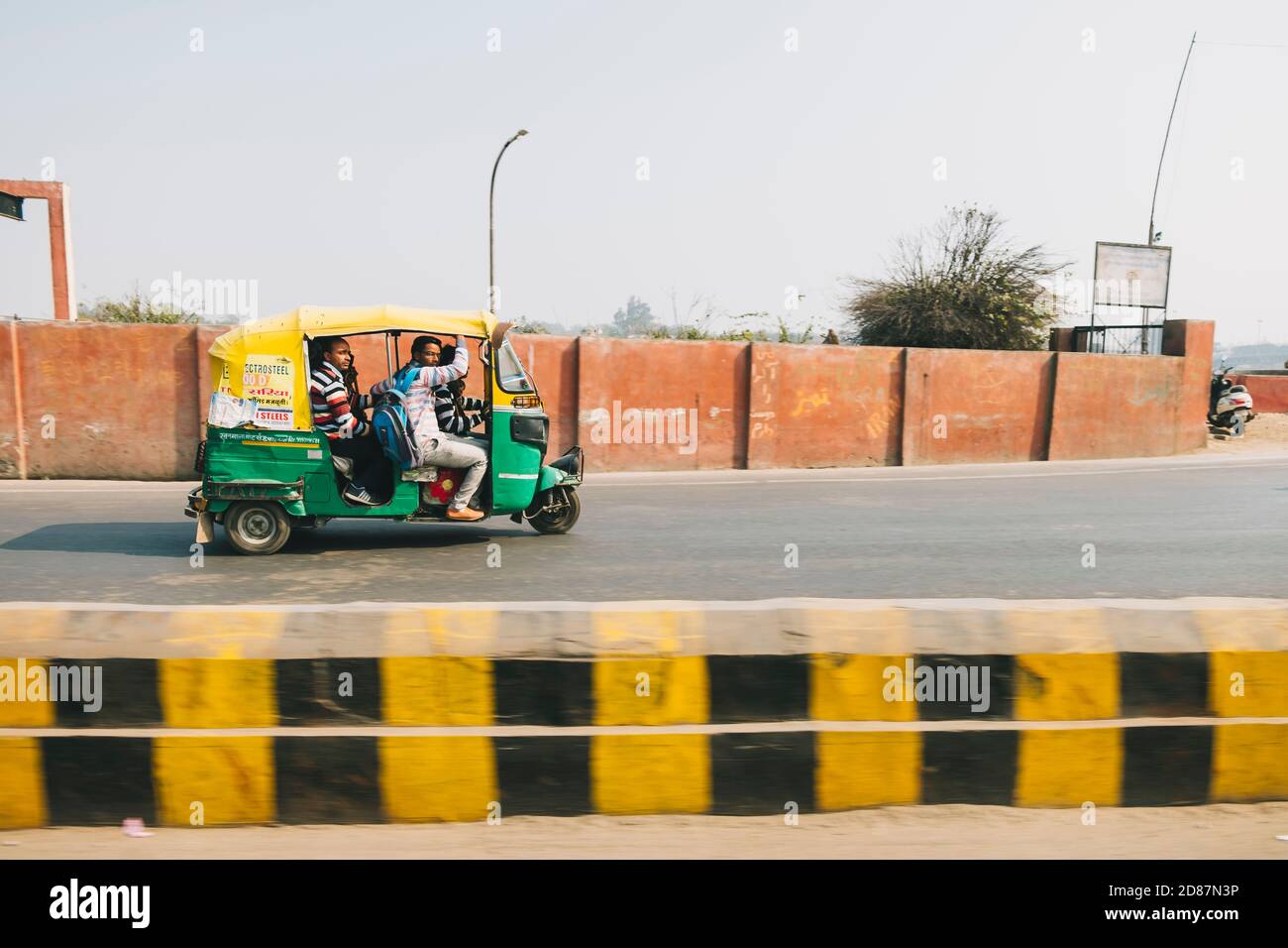 Local auto passing by the streets in Agra with a group of local Indian ...