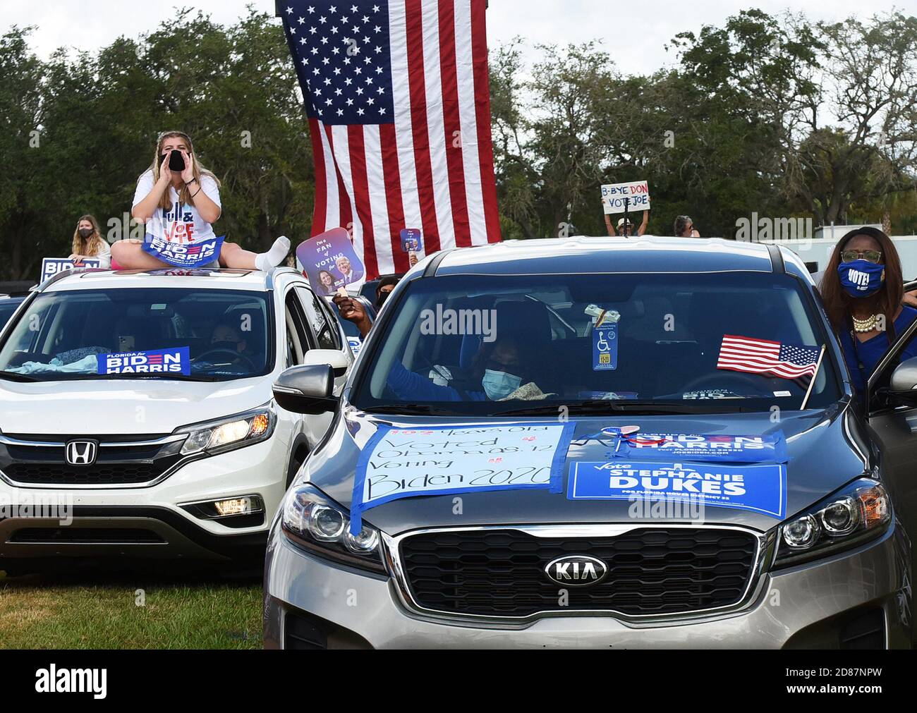 A supporter chanting slogans while sitting on top of a vehicle during ...