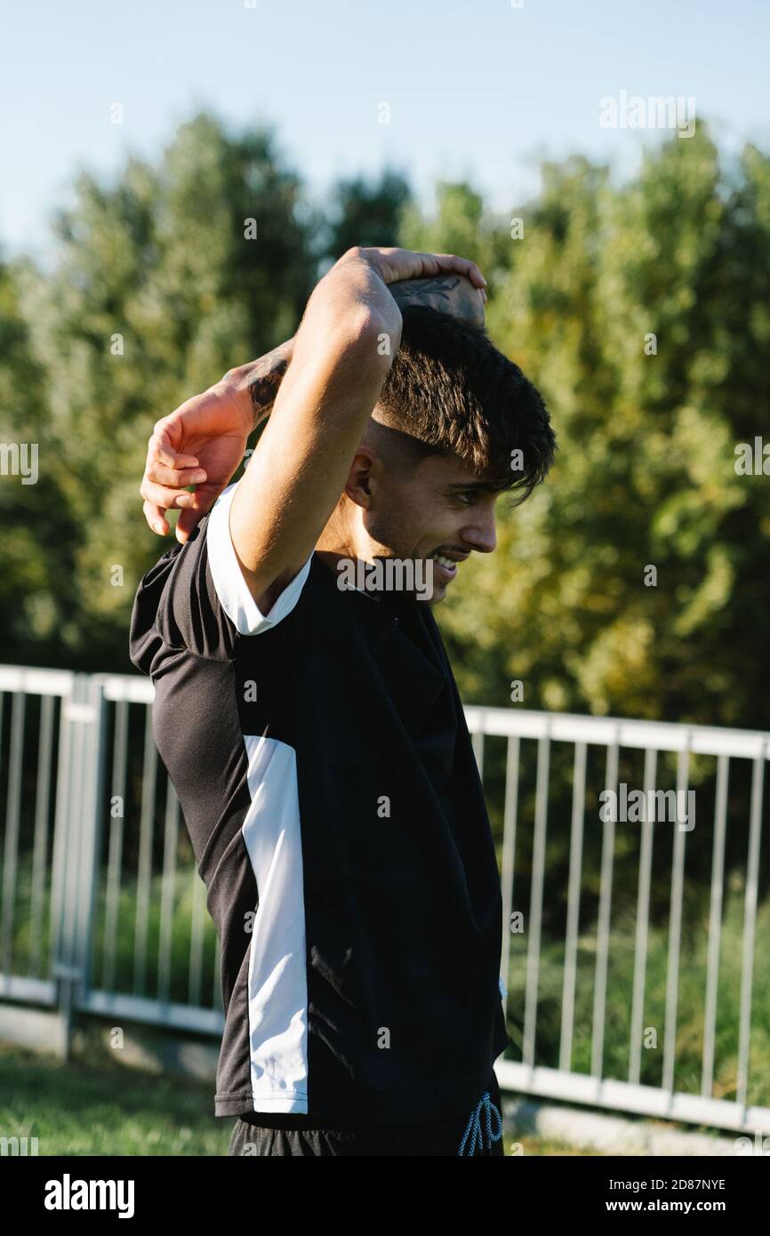 Boy warming up for sports. Boy does arm stretches Stock Photo - Alamy