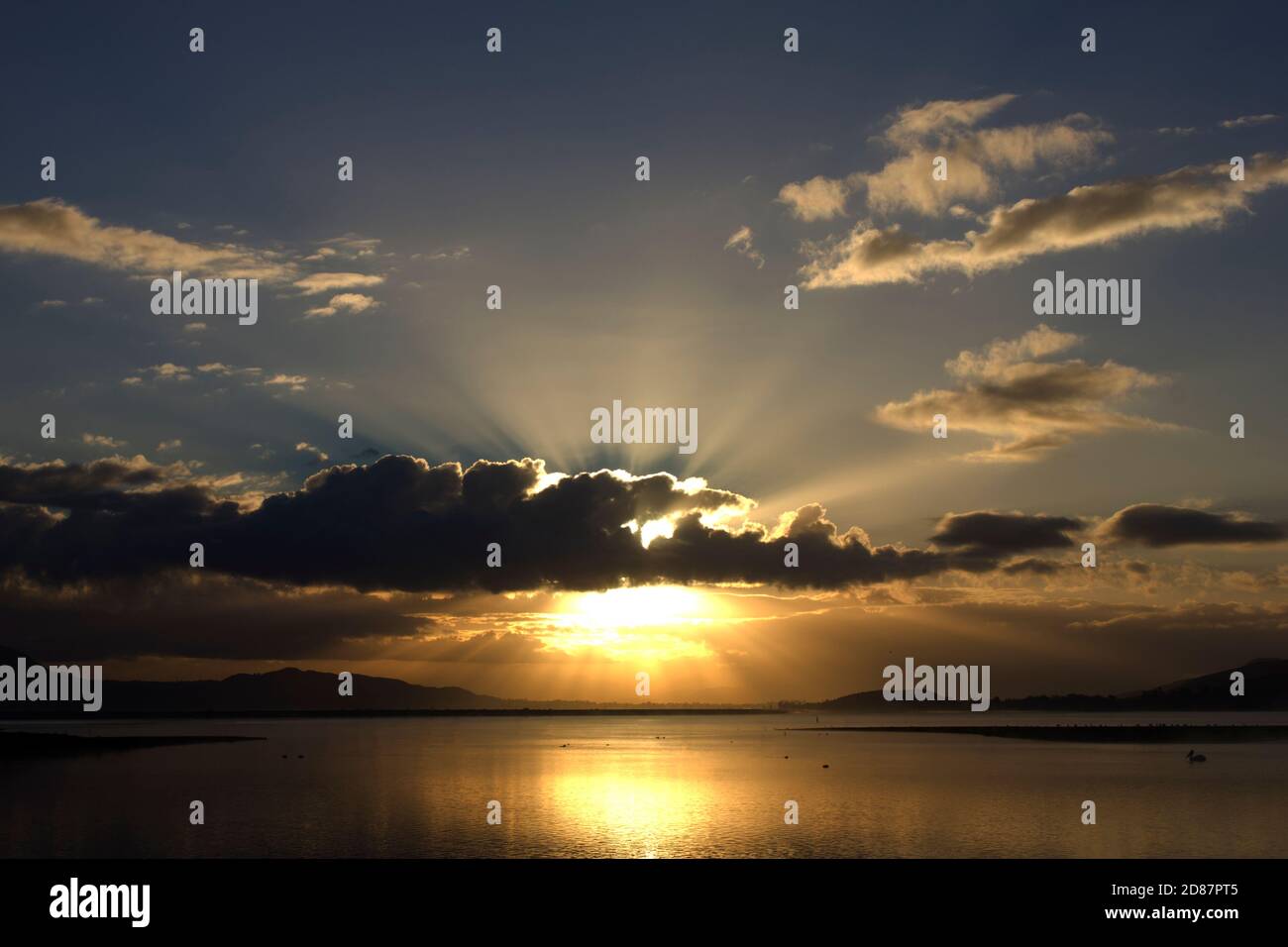 Sun beams from sun behind morning clouds Stock Photo - Alamy