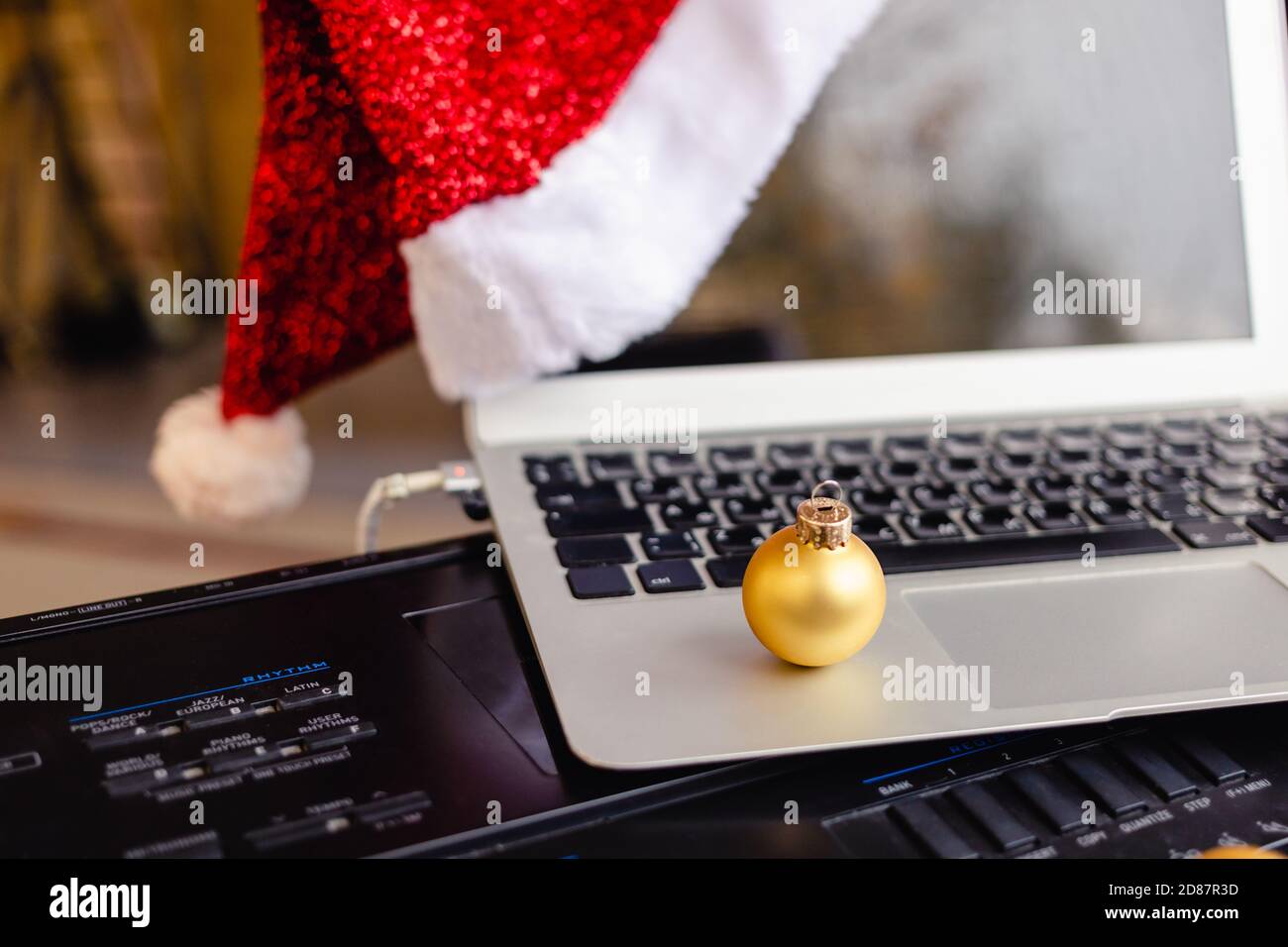 Christmas ball and laptop with santa hat on piano keys Stock Photo - Alamy