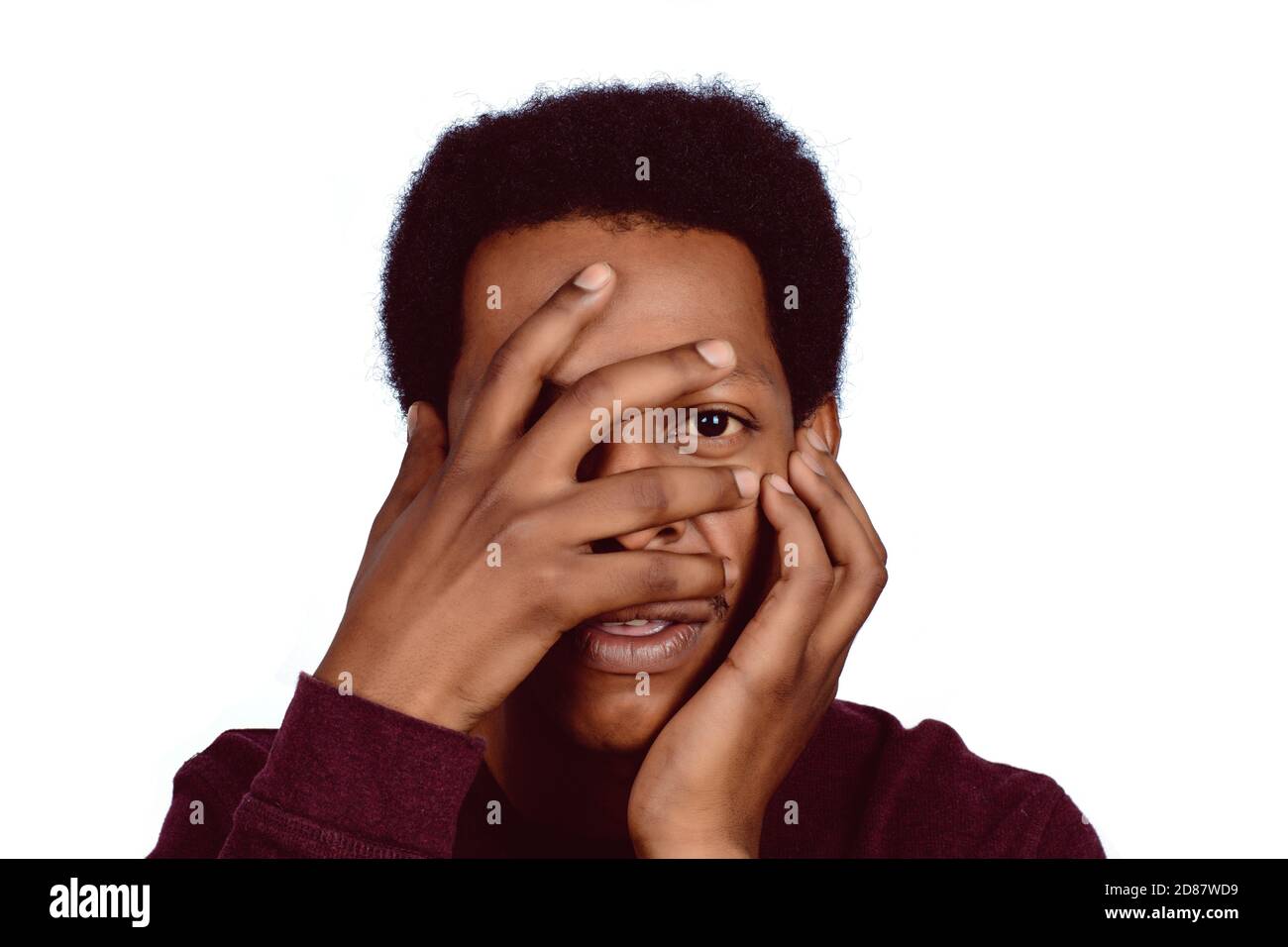 Portrait of Afro American man covering his face with hand against white ...