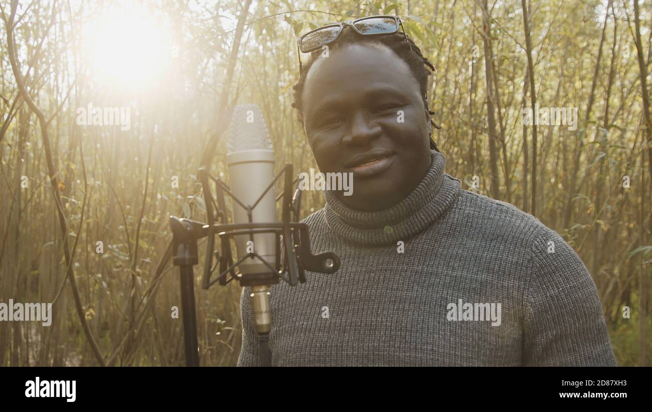 Young african american black man singing in the microphone in the woods ...