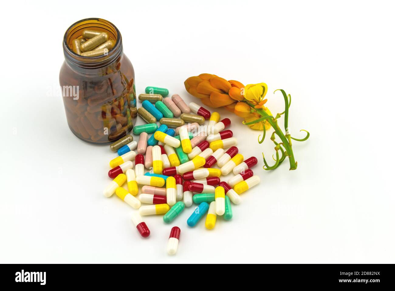 Colorful tablets medicine in black bottle and fresh flower of Senna ...