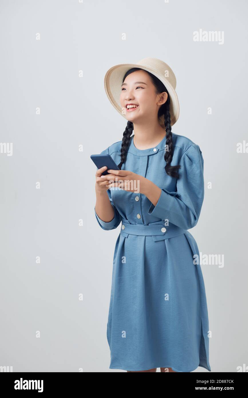 Cheerful young woman reading text message on her cell phone against ...