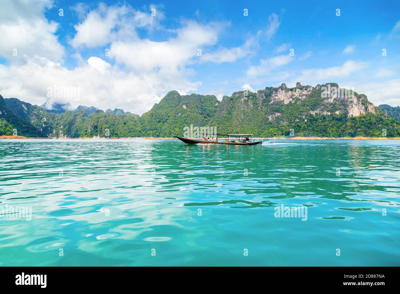 Wooden Thai traditional long-tail boat on a lake with mountains at ...