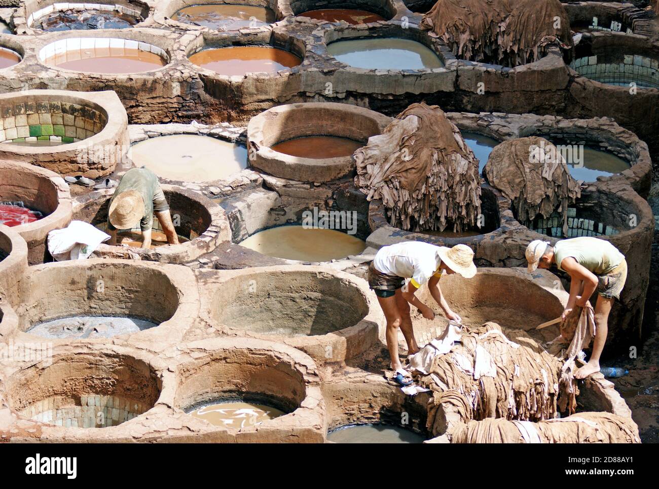 Three Moroccan men prepare rawhide for softening and dyeing in the ...
