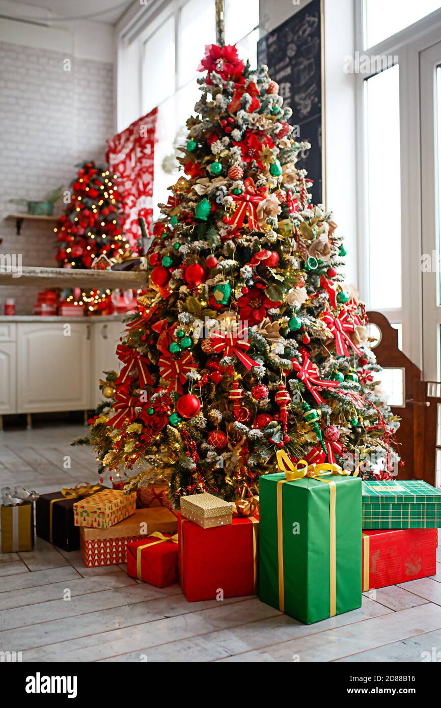The Christmas tree is decorated with red and green toys, boxes with ...