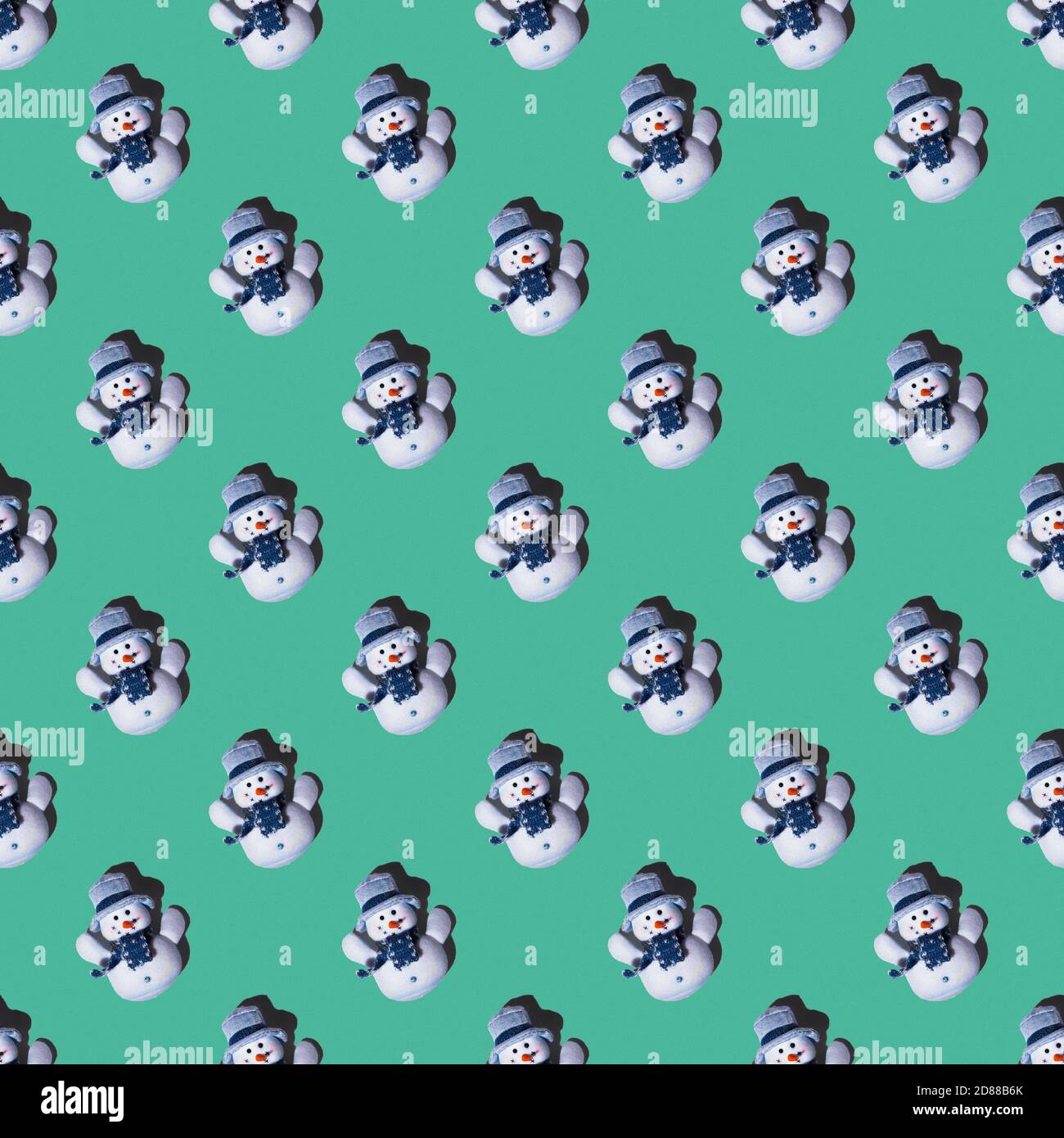 Festive seamless pattern toy snowmen on a green background, minimalism ...