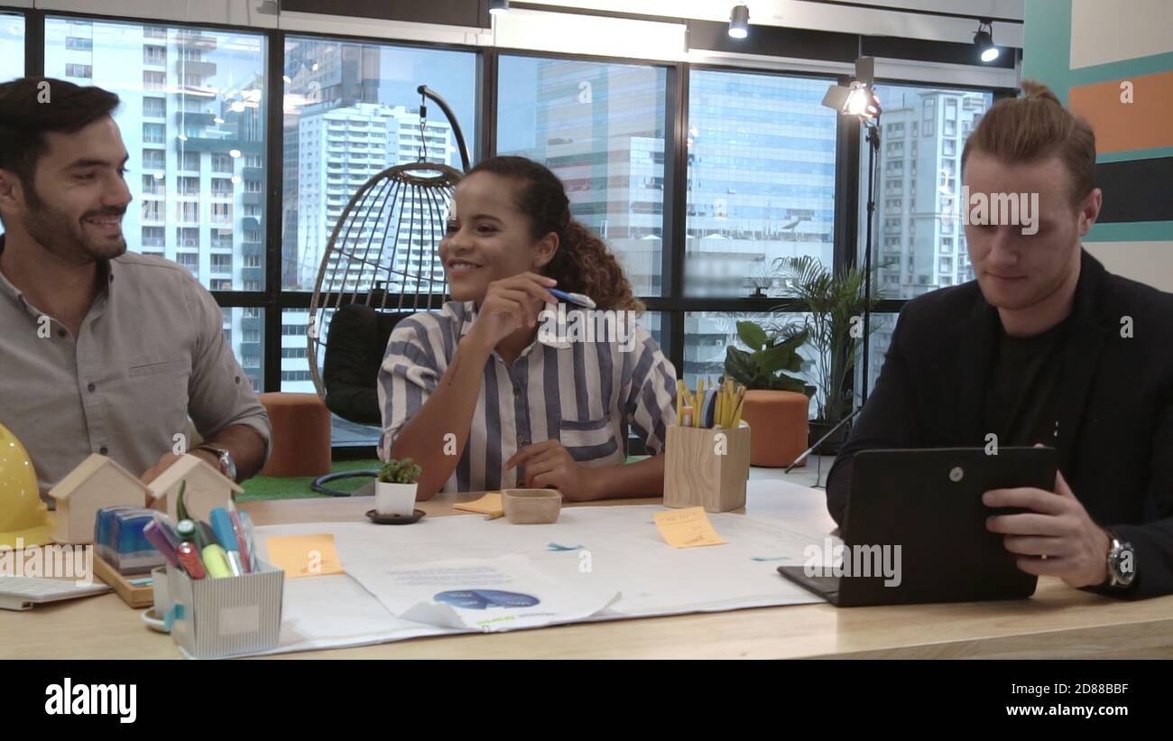 Creative business people group having conversation at office desk in ...