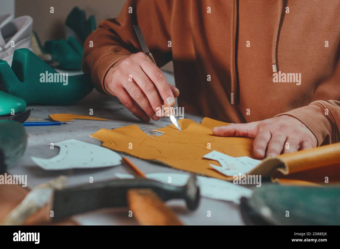 Shoemaker cutting patterns using knife from leather Stock Photo - Alamy