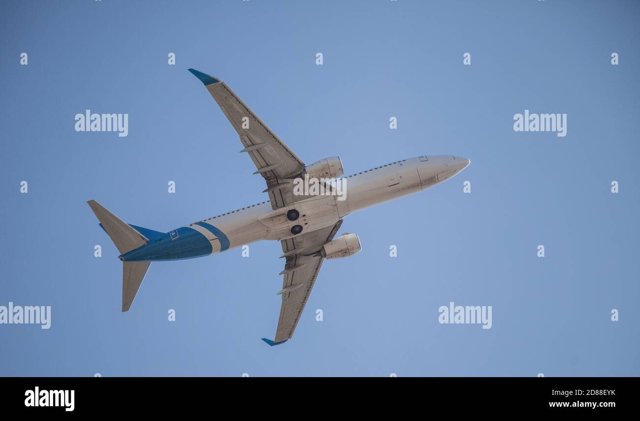 White plane flies in the sky. Bottom view. Takeoff and landing. Arrival ...