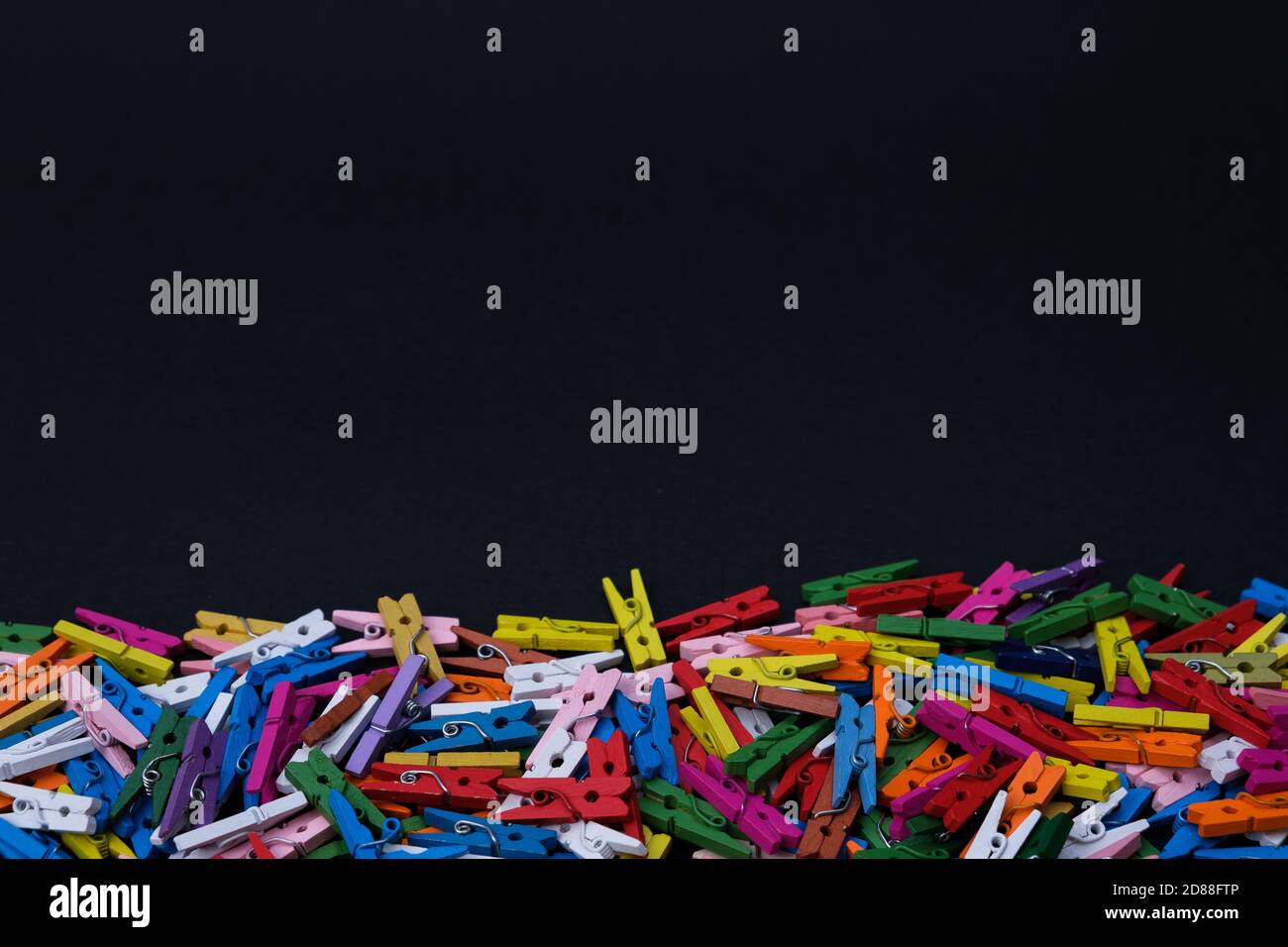 Colored wooden clothes pegs on black background, colorful banner with ...